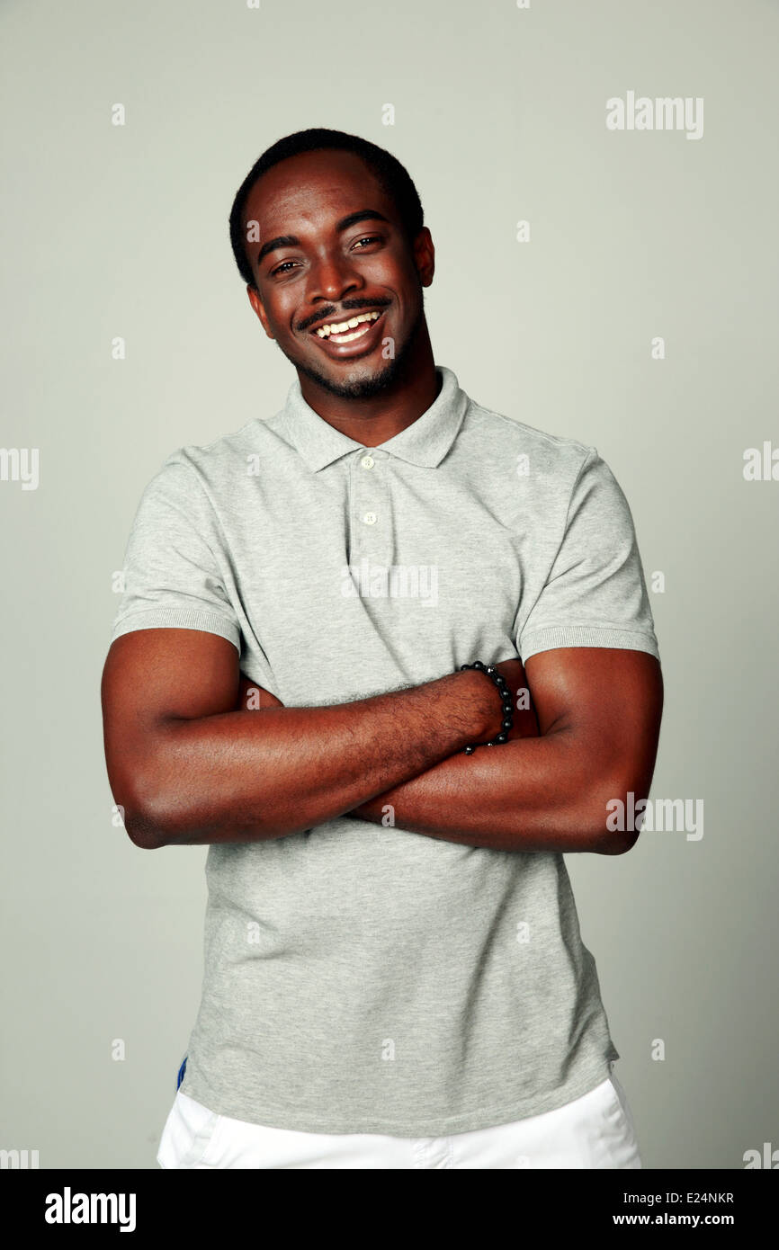 Happy African Man With Arms Folded Standing On Gray Background Stock