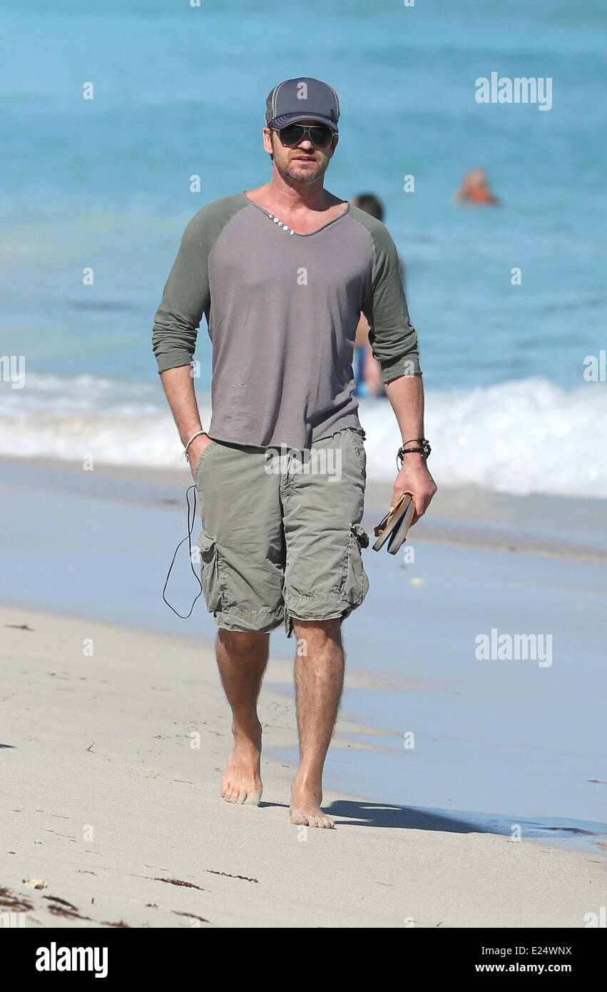 Gerard Butler enjoys a walk barefoot along Miami Beach accompanied by ...