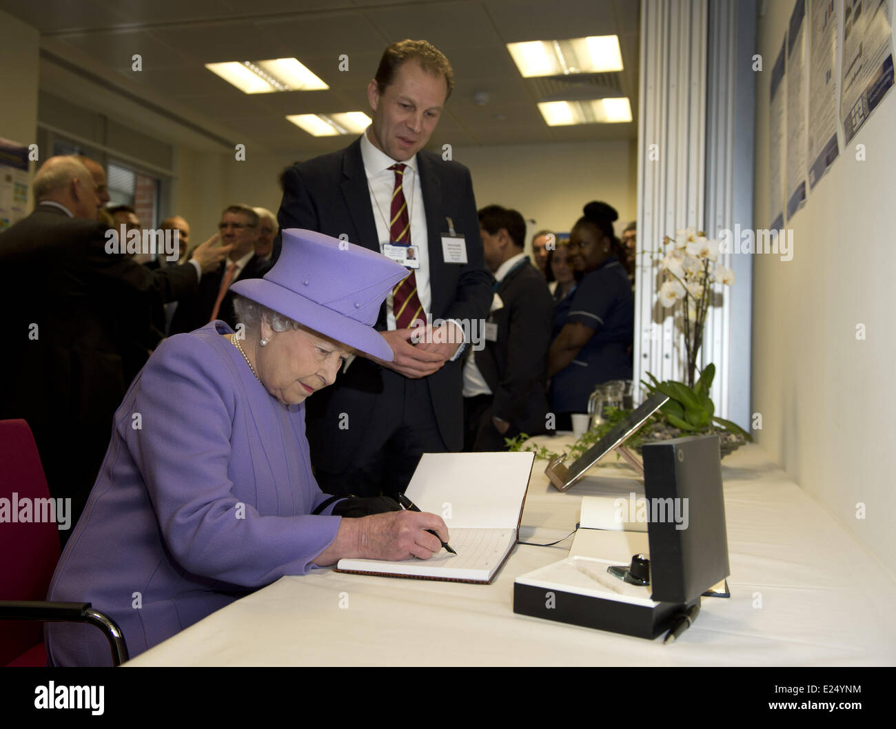 Britain's Queen Elizabeth II signs a commeorative book alongside ...