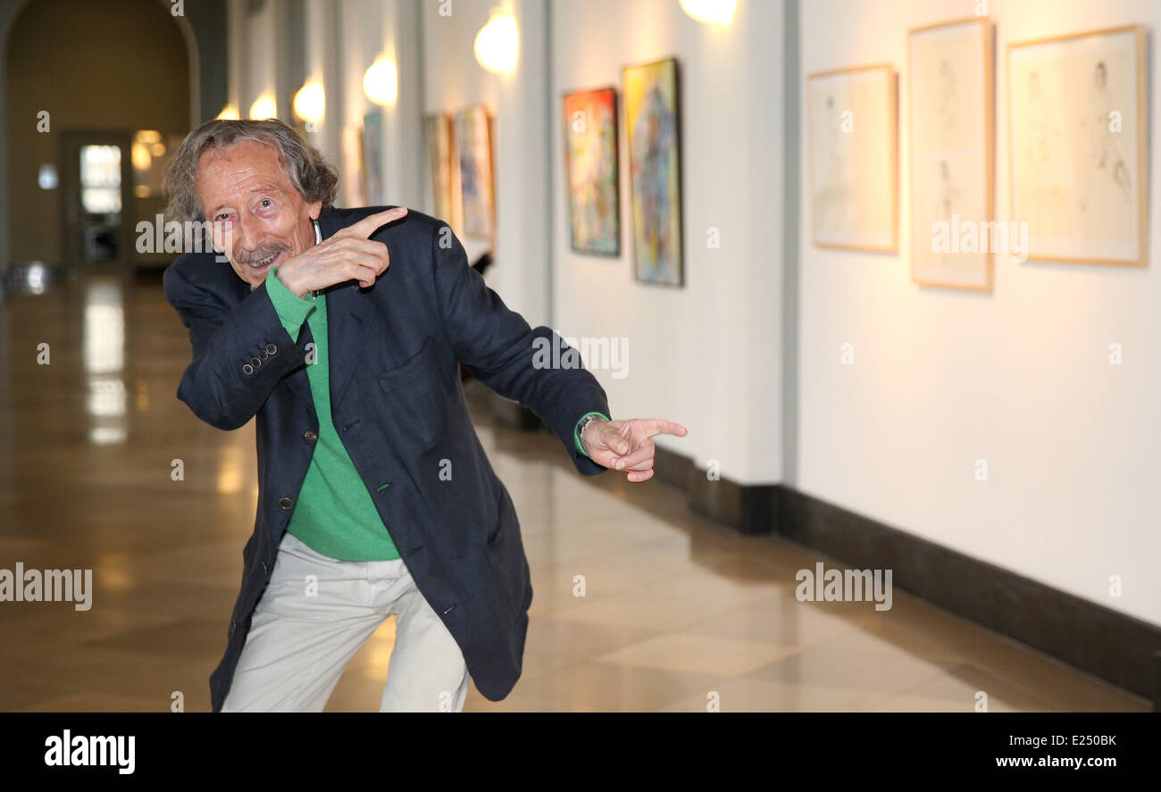 Painter Armin Sandig poses in front of his paintings at his exhibition ...
