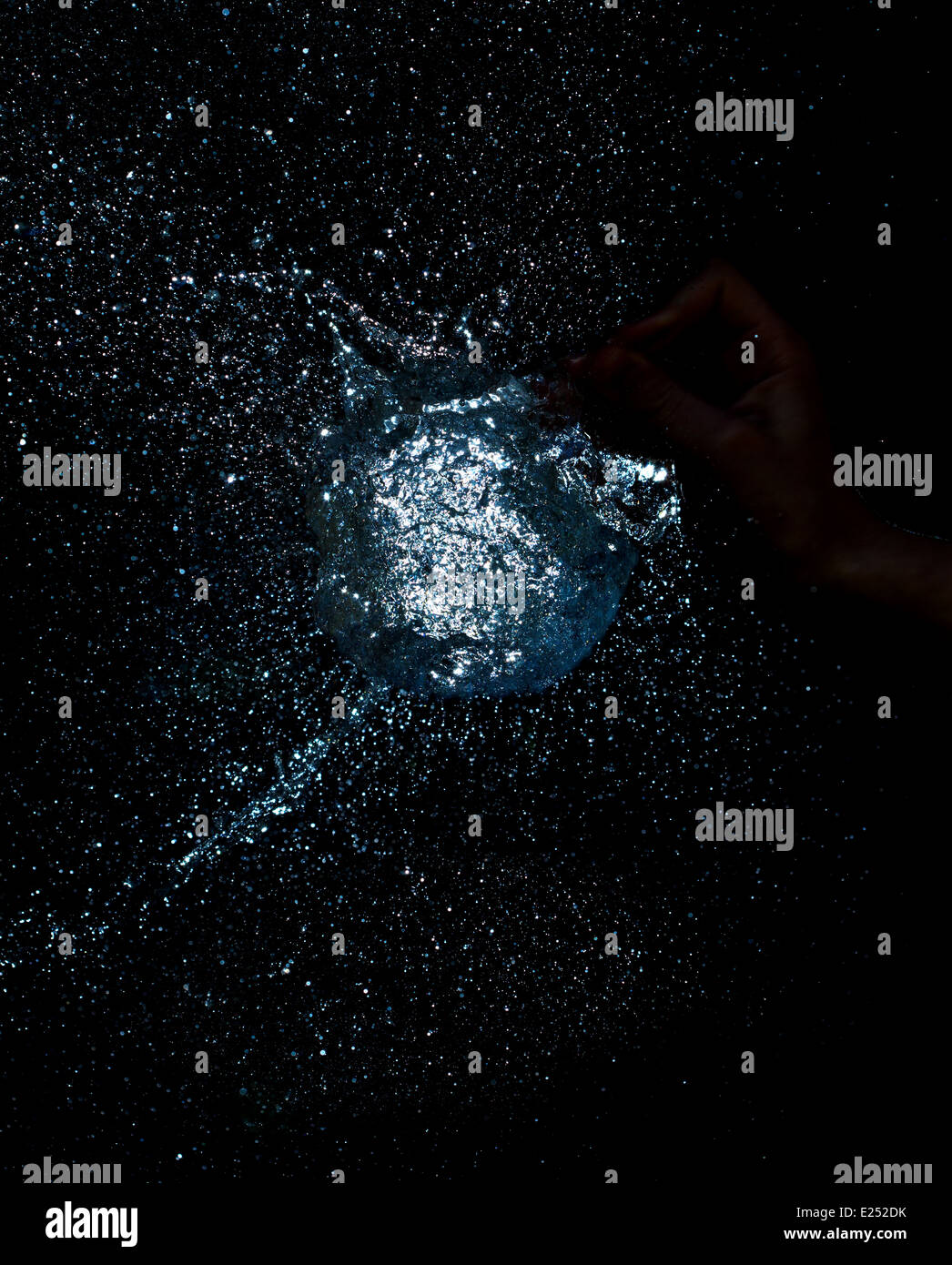 water balloon bursting on black background Stock Photo - Alamy
