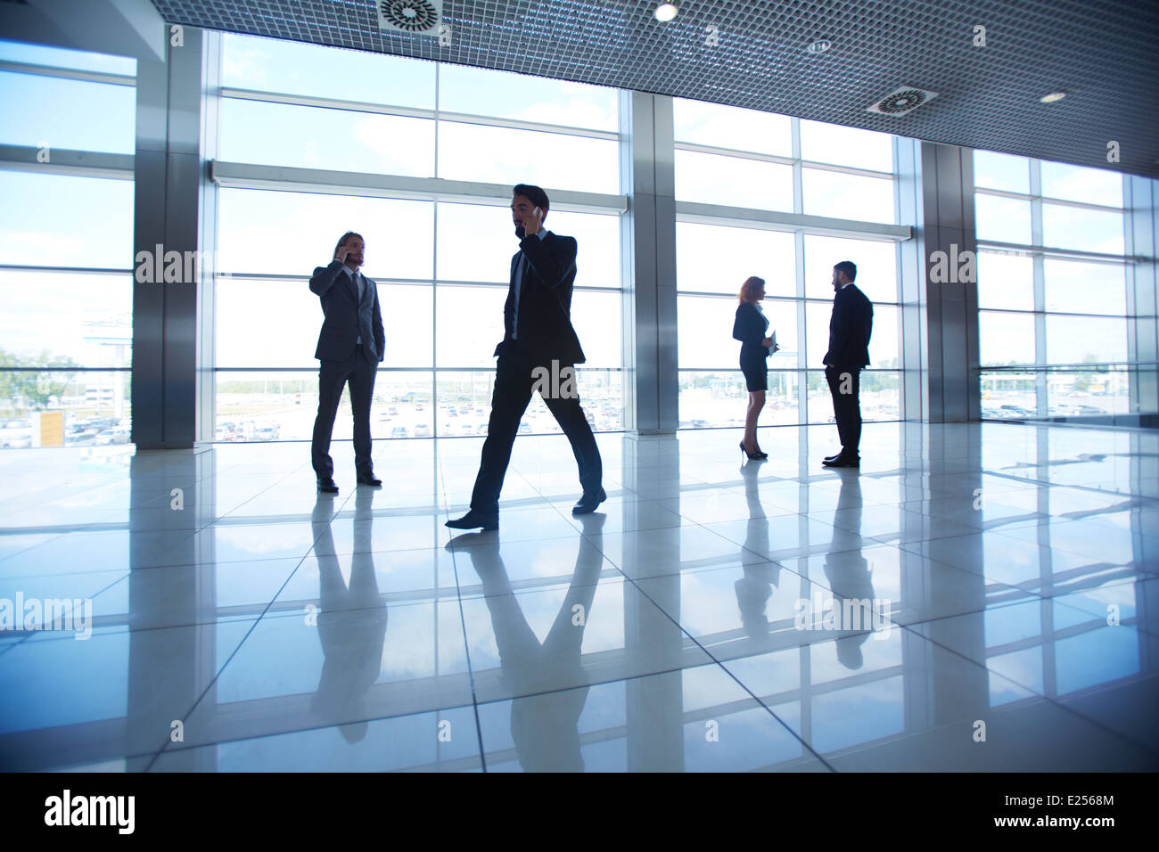 Several office workers on background of window Stock Photo - Alamy