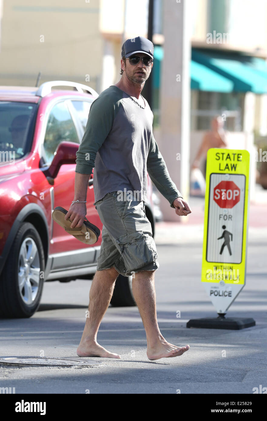 Gerard Butler enjoys a walk barefoot along Miami Beach accompanied by ...