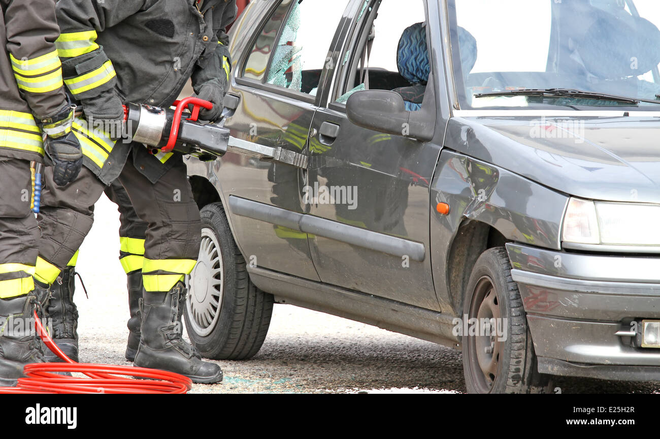 firefighters with the pneumatic shears open the car doors after a ...