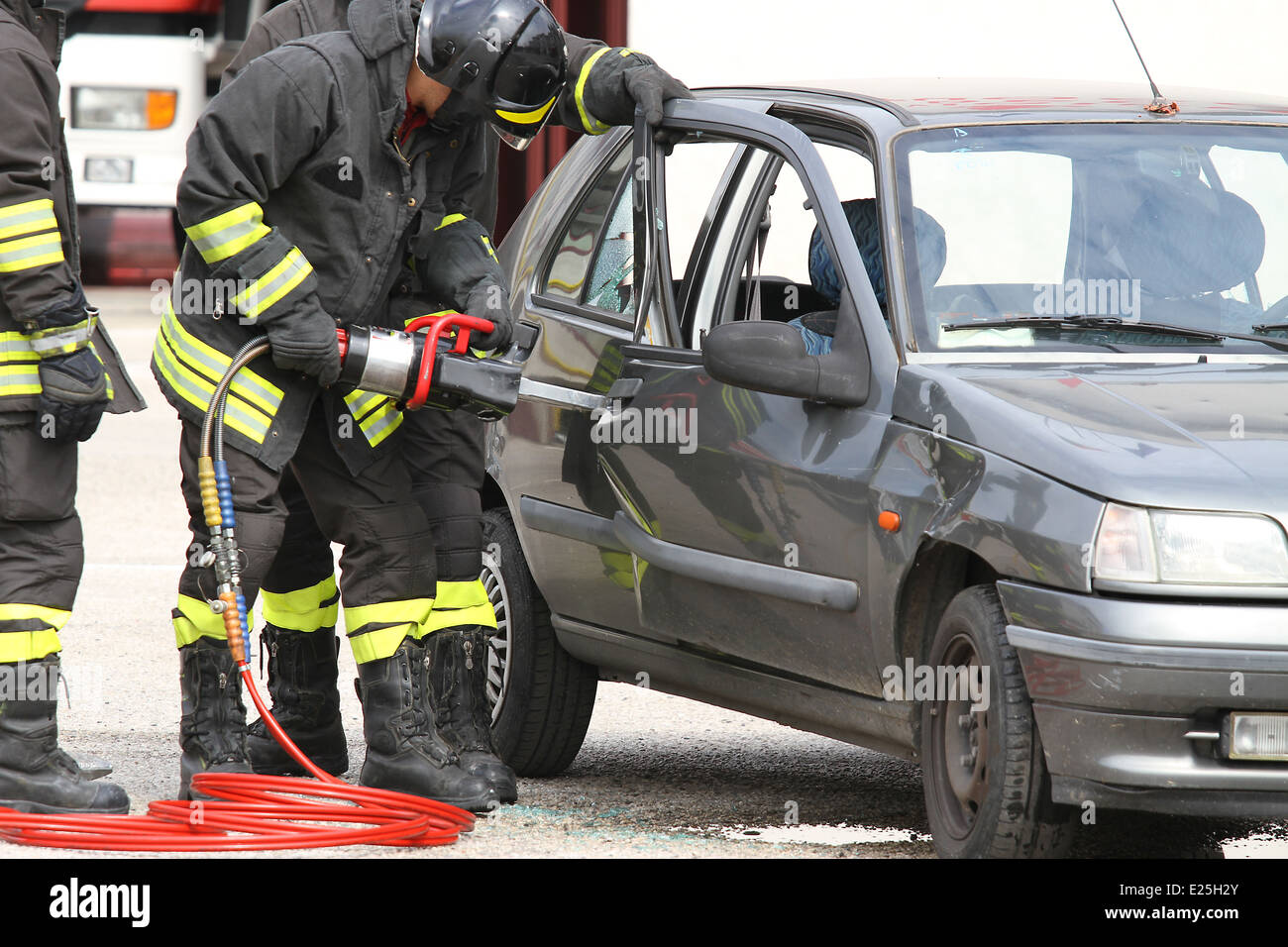 firefighters with the pneumatic shears open the car doors after a car ...