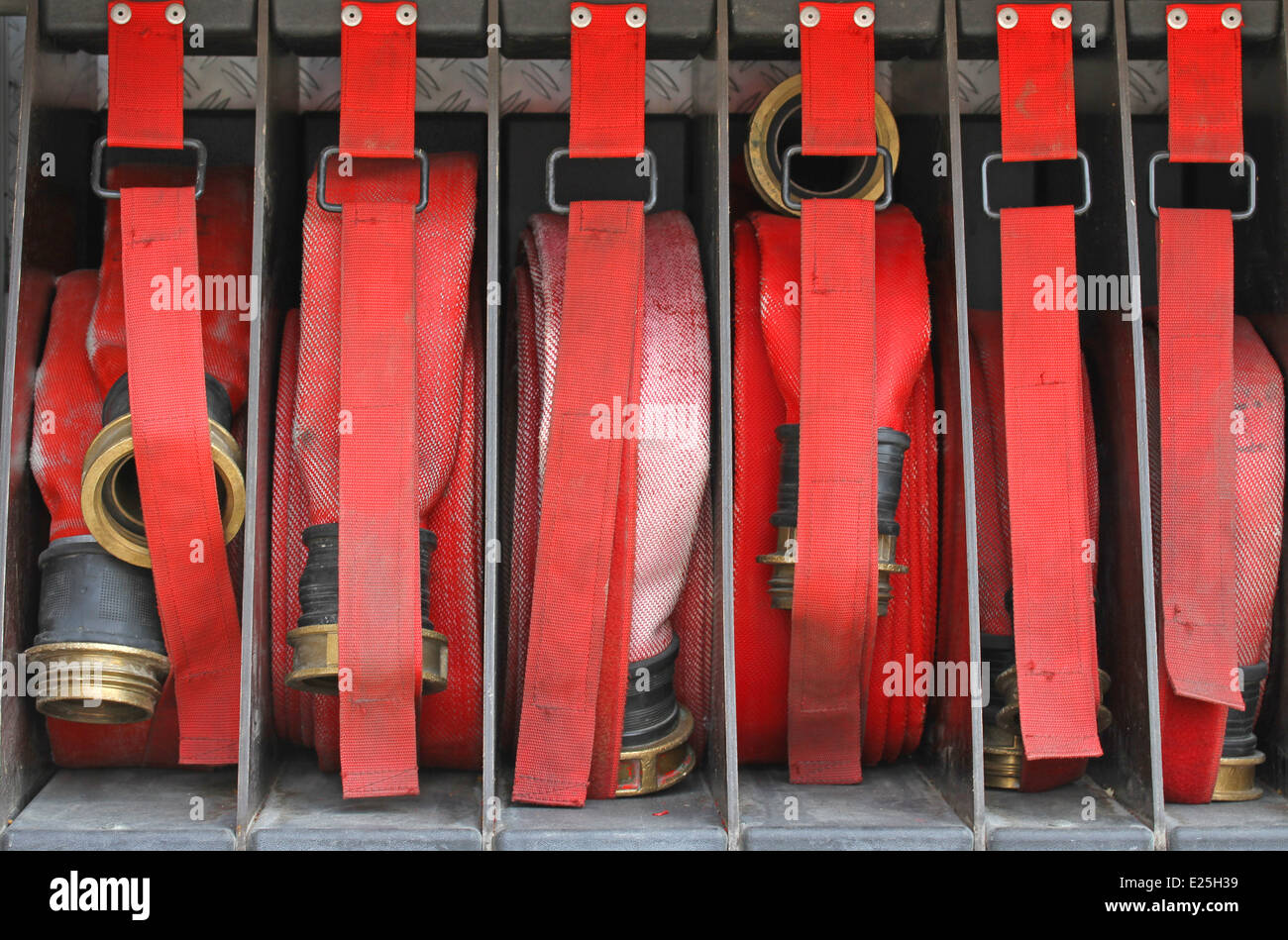 Six red hoses of firefighters in order inside the fire truck ready to ...