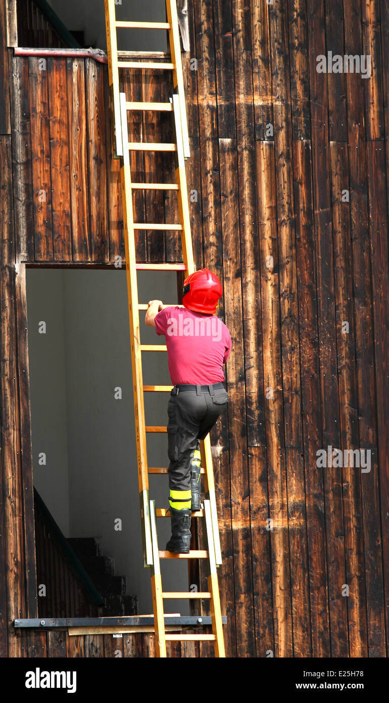 intrepid head of firefighters climbing a ladder during a practice ...