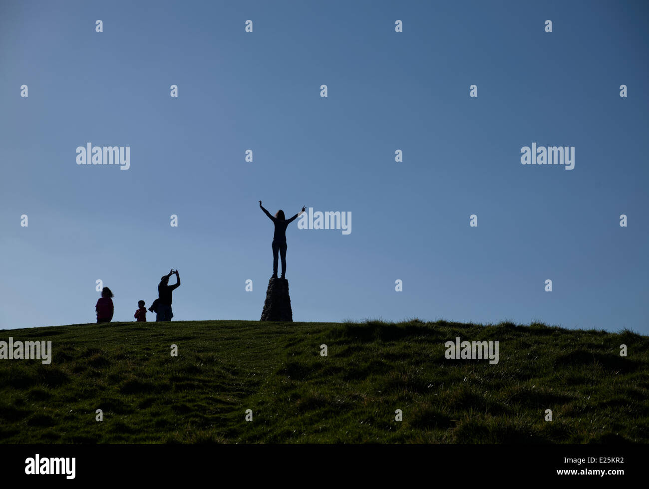 Person standing on a Triangulation pillar with arms outstretched in the ...