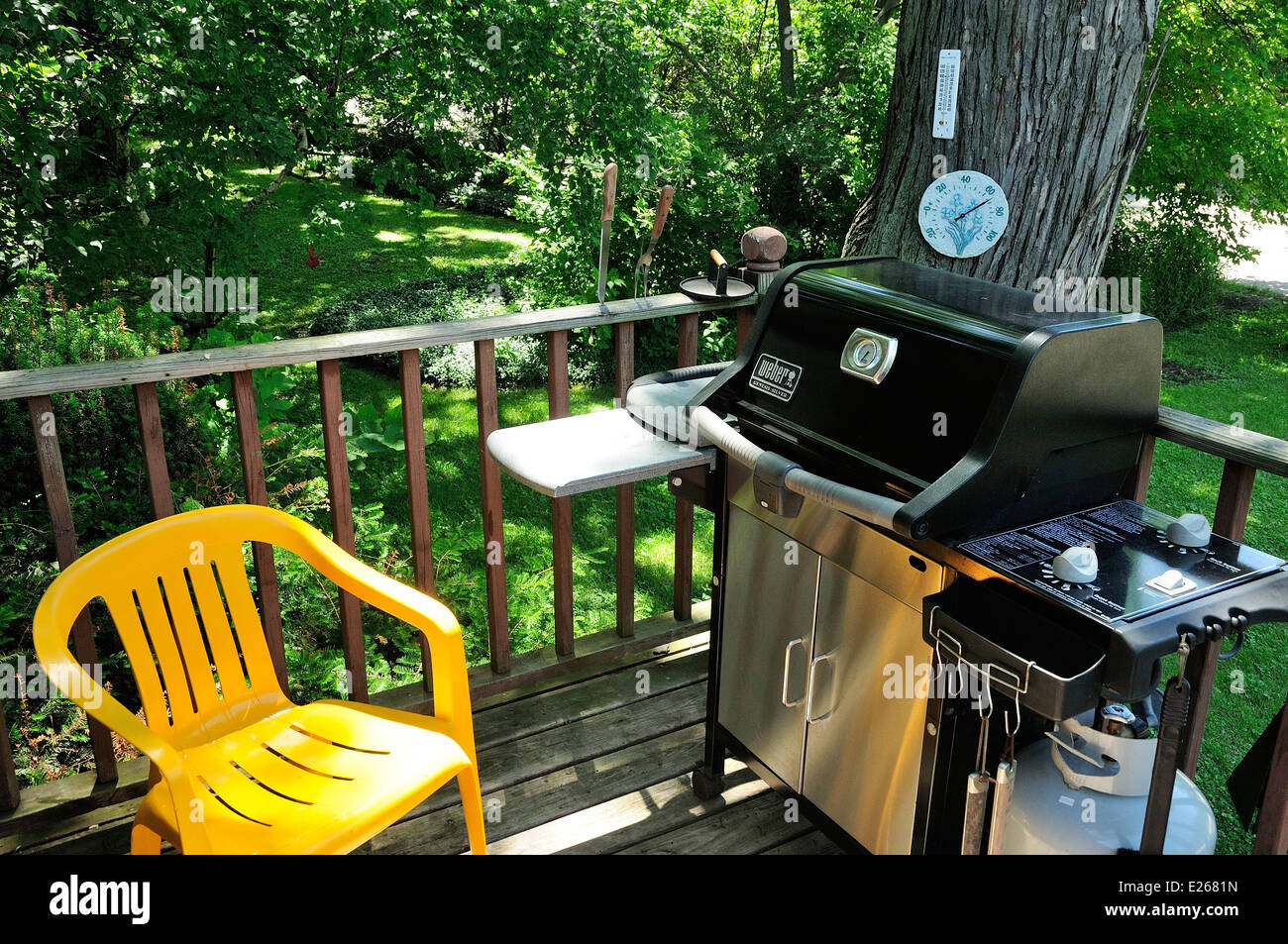 Porch with BBQ grill and brightly painted chairs Stock Photo - Alamy
