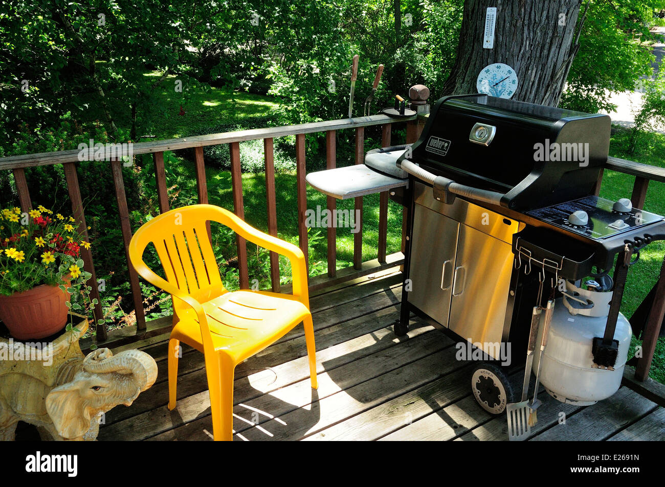 Porch with BBQ grill and brightly painted chairs Stock Photo - Alamy