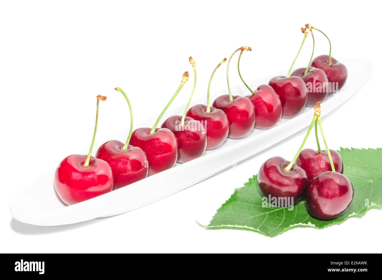 Big dark red ripe cherry berry row arranged on long white dish and ...
