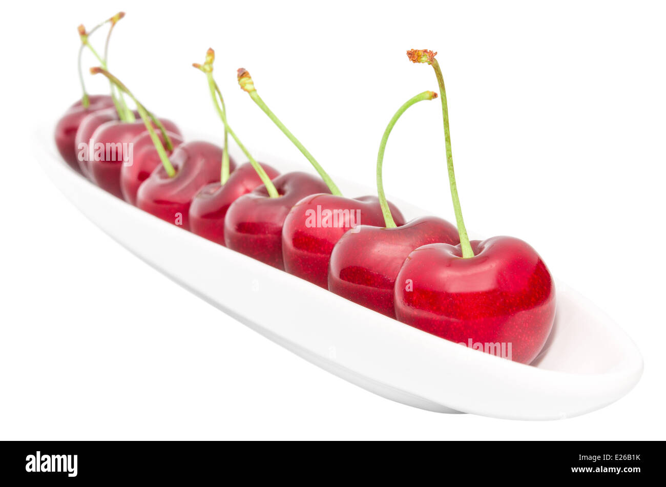Appetizing ripe cherry berry row on long olive dish isolated on white ...