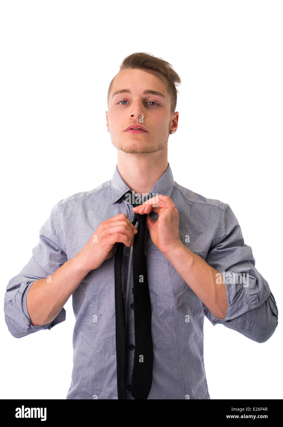 Elegant young man wearing and adjusting neck-tie, isolated on white ...