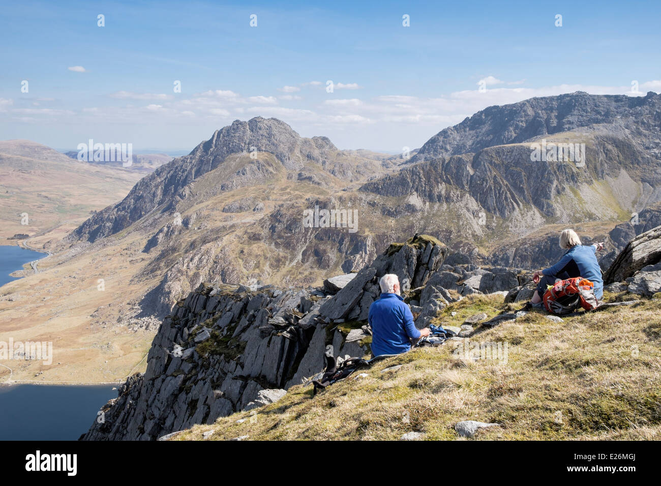 Hikers resting on Y Garn with view to Mount Tryfan and Glyderau in ...