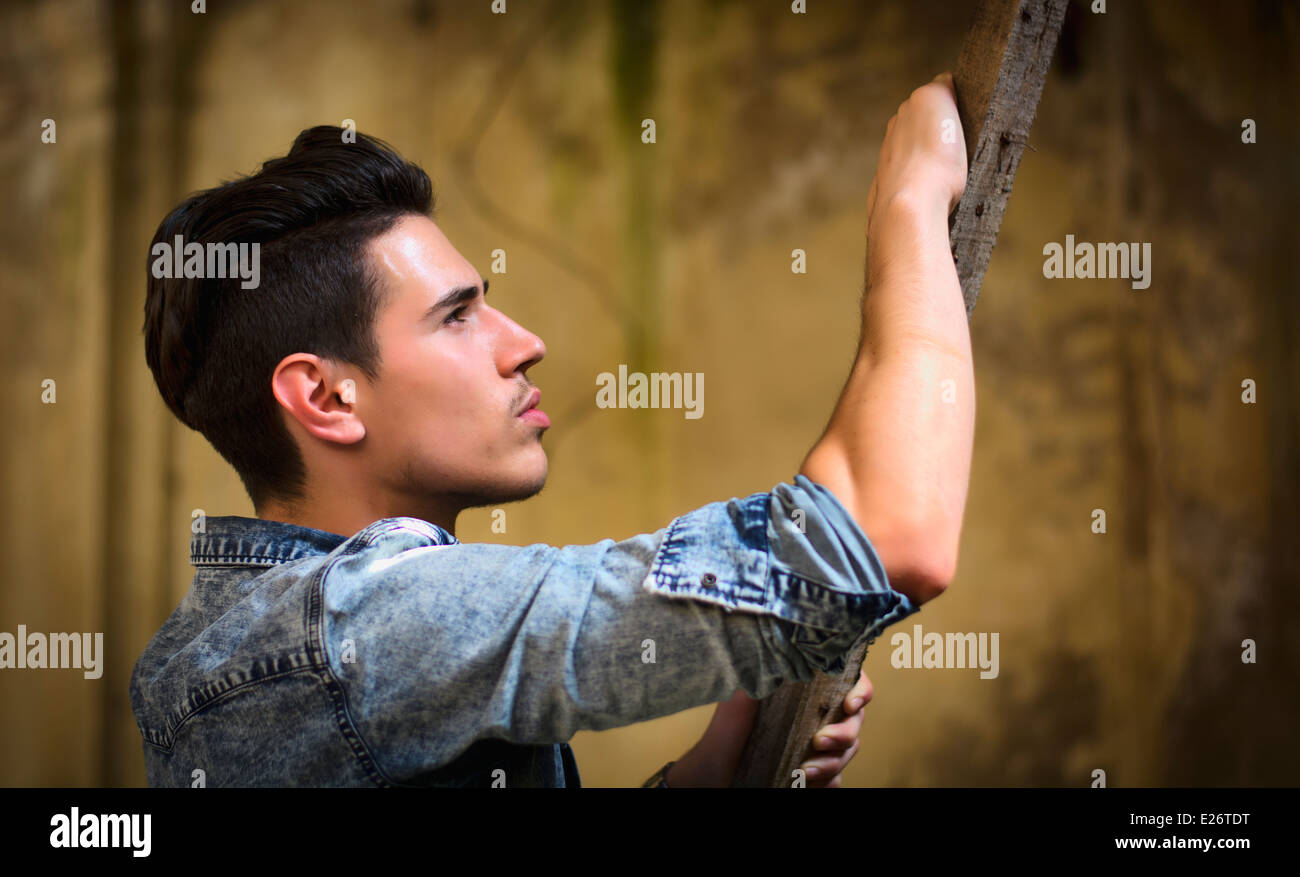 Profile of handsome young man in abandoned building looking up Stock ...