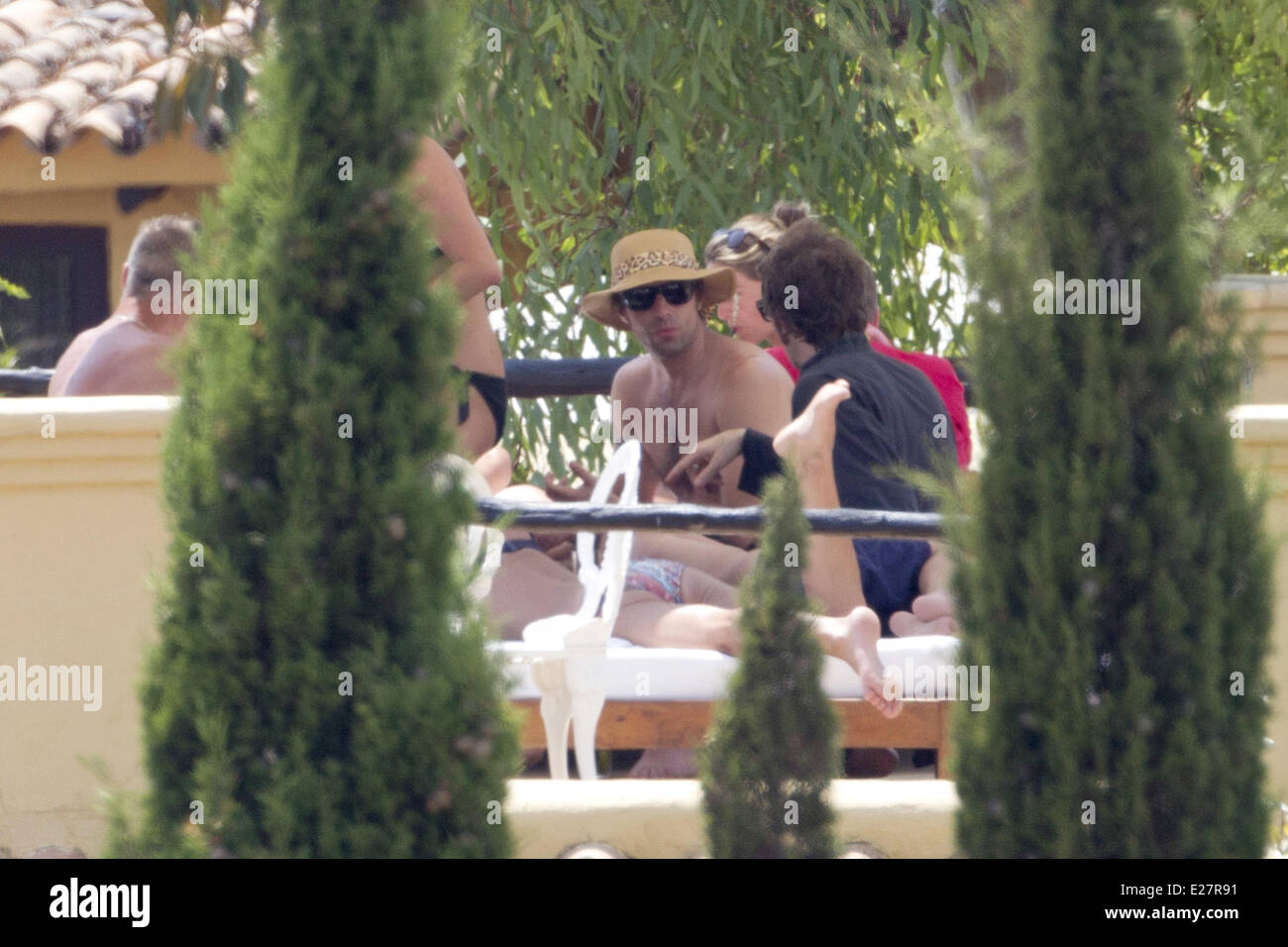 Liam Gallagher and friends sunbathing by the pool at Pikes Hotel in ...