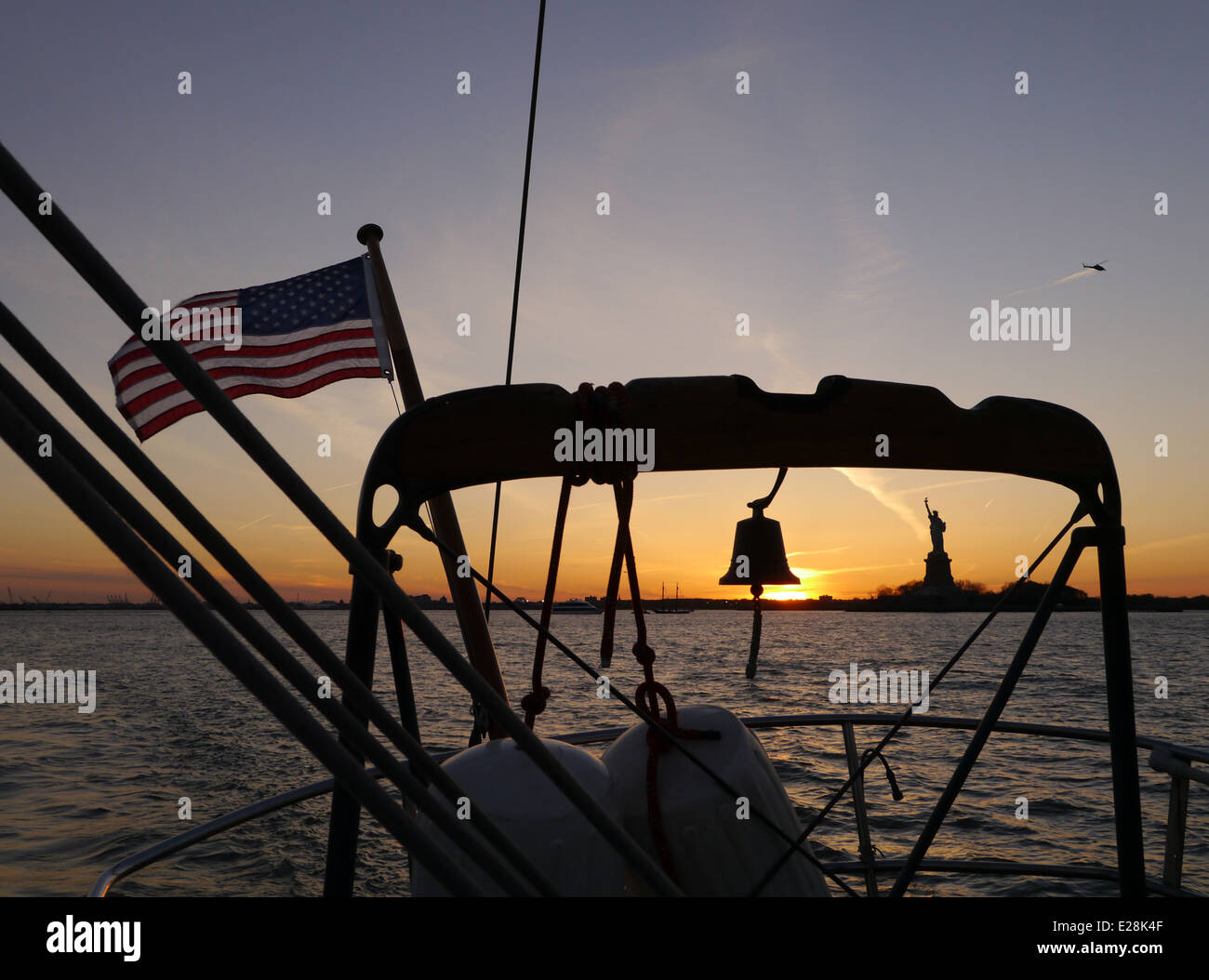 The American flag flying over the Statue of Liberty in the distance at ...