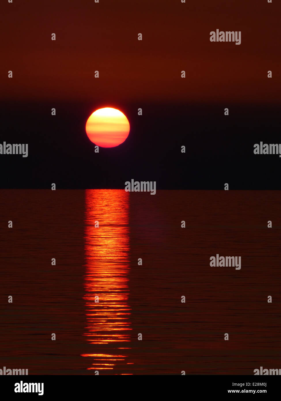 Sunset over water with stripes and a dramatic abstract reflection Stock ...