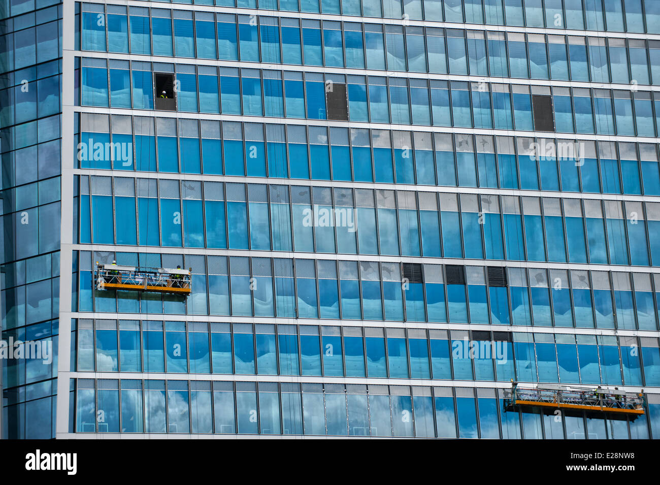 Workers clean skyscraper glazing from cradles Stock Photo - Alamy