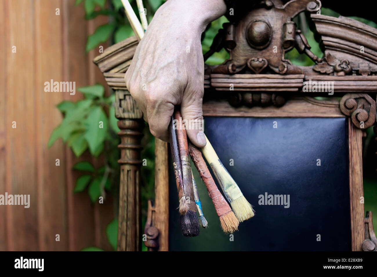 Hand of an artist holding brushes Stock Photo - Alamy
