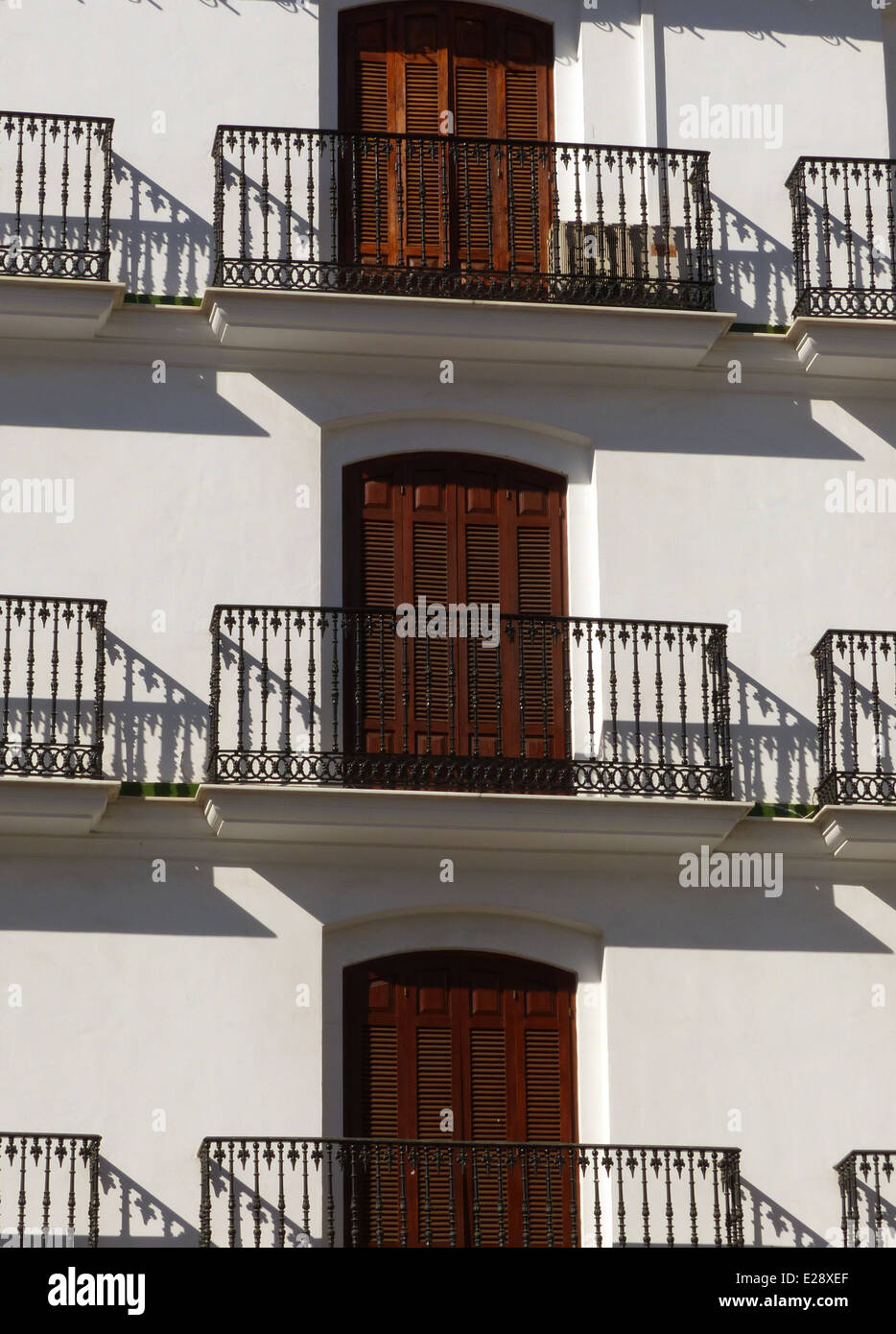 A traditional Spanish building with shuttered windows and wrought iron ...