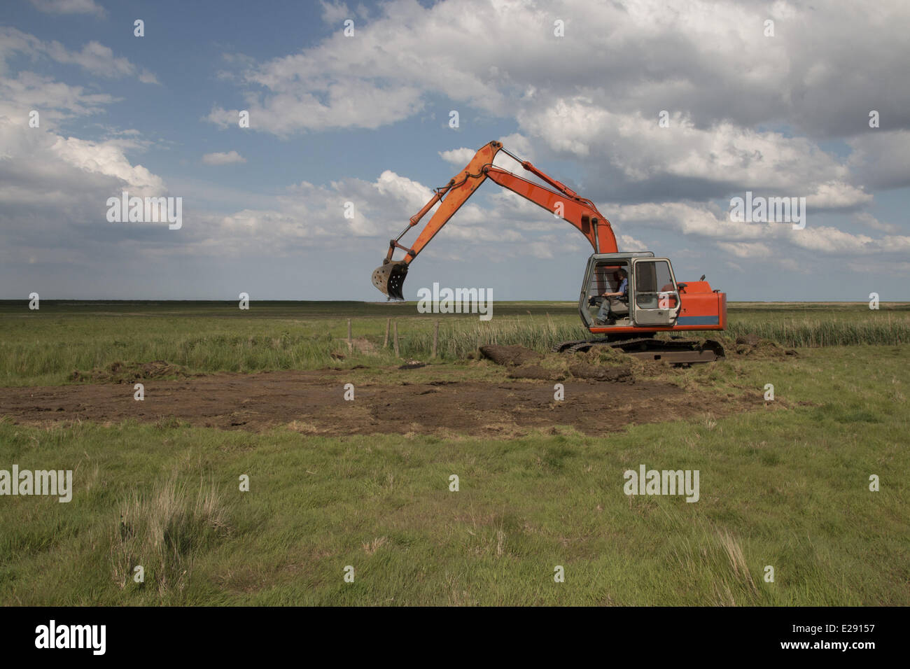 Using a digger for maintenance work on Deepdale Marsh north Norfolk ...