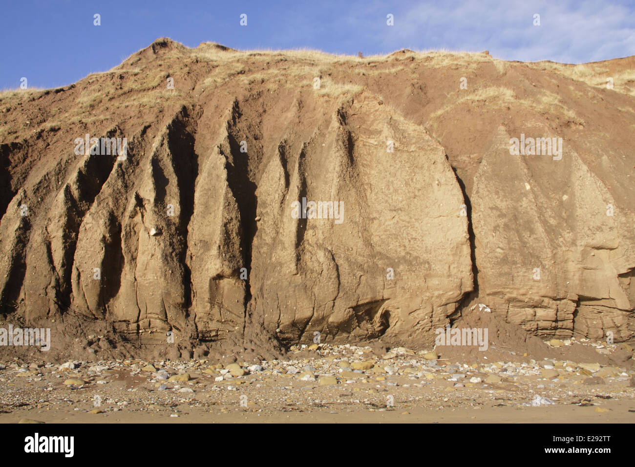 Eroded sea cliffs and pebbles on beach, Filey Bay, Filey, East ...