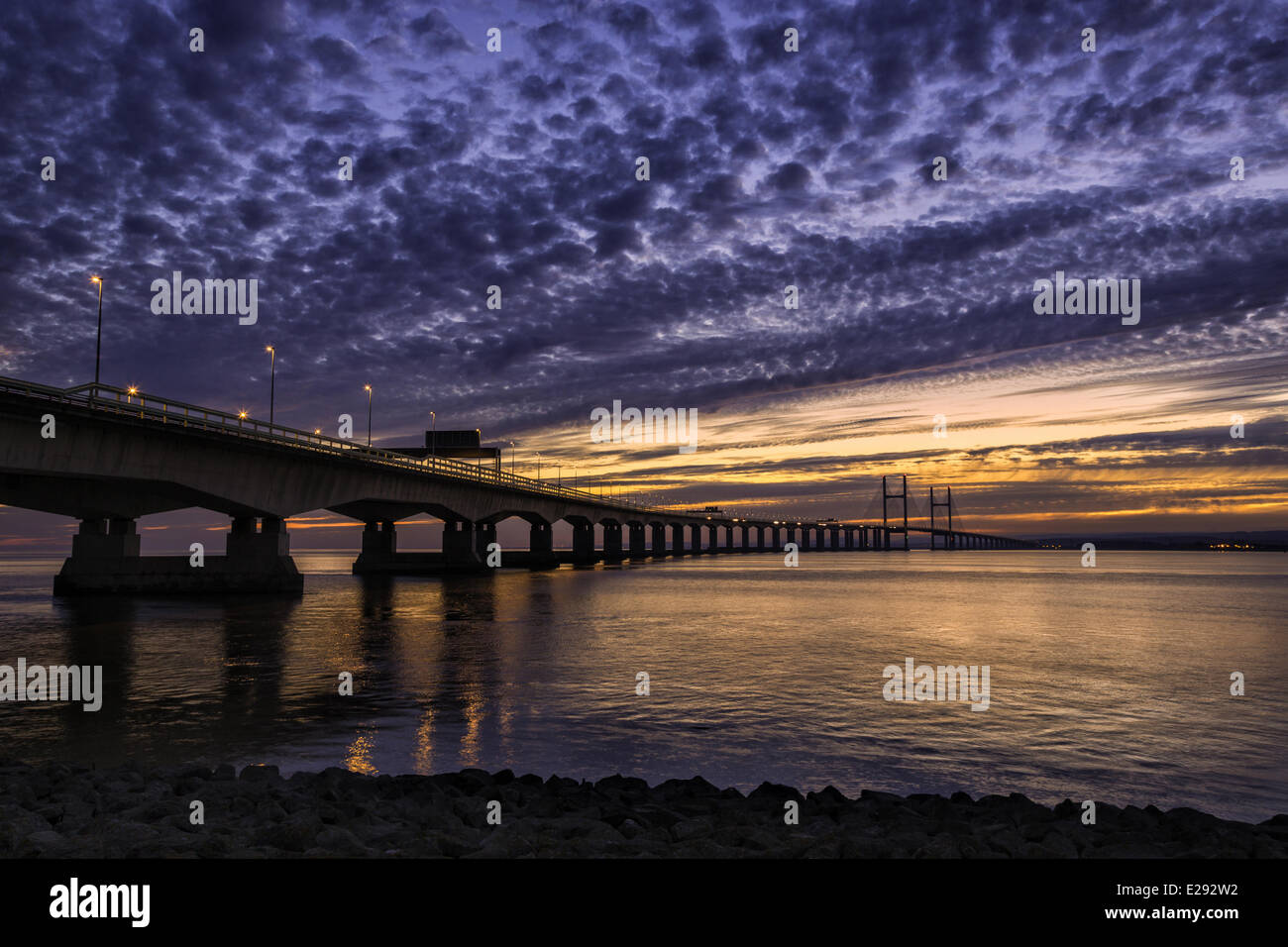 View of road bridge over river at sunset, viewed from Severn Beach ...
