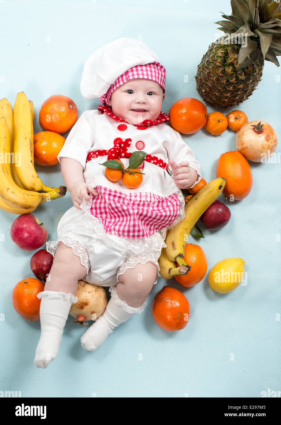 Baby cook girl wearing chef hat with fresh fruits. Use it for a child ...
