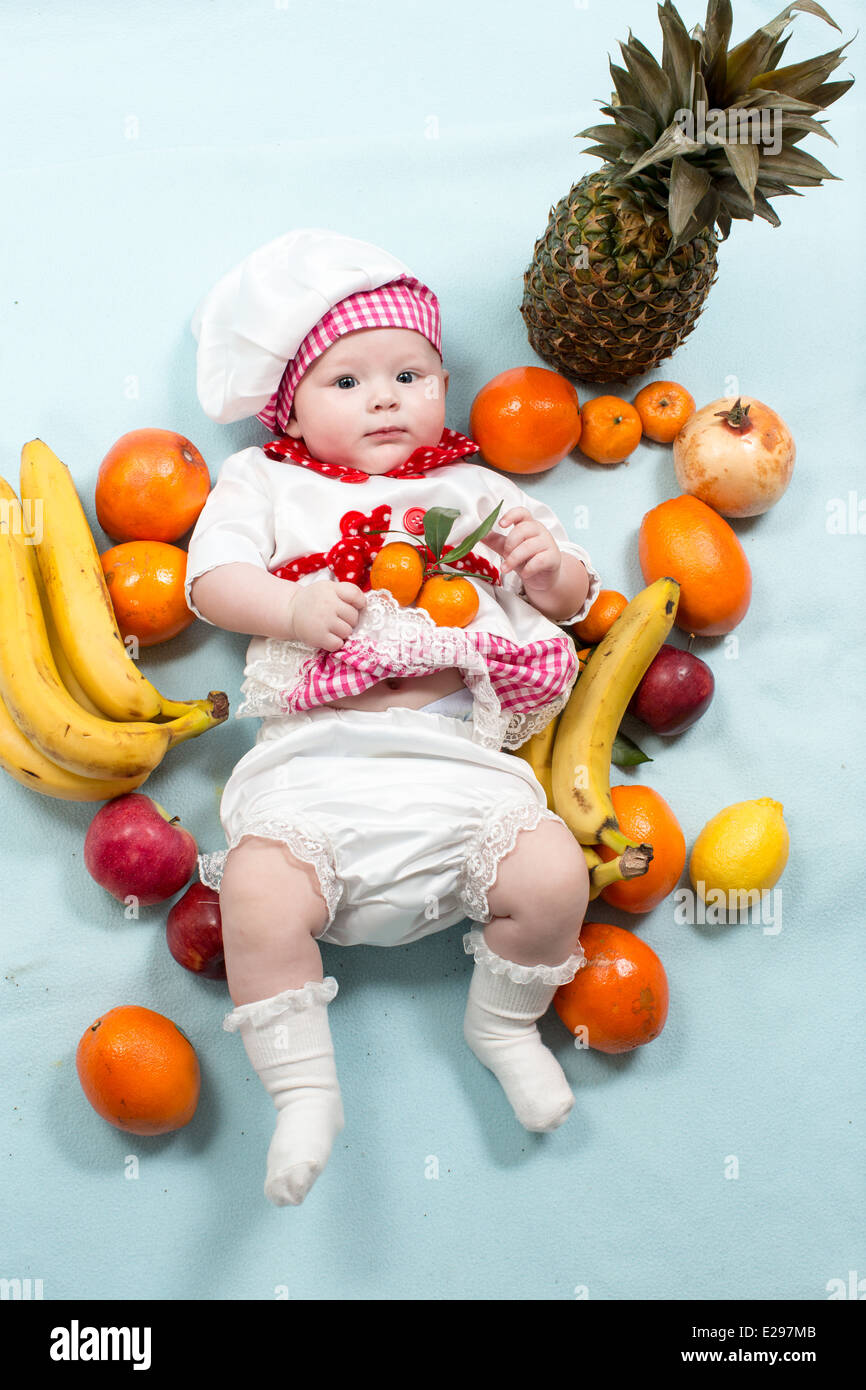 Baby cook girl wearing chef hat with fresh fruits. Use it for a child ...