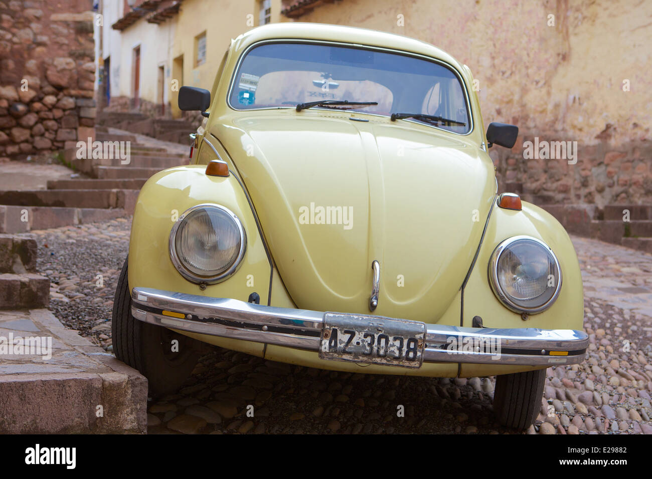 A pretty street scene with yellow vw bug on a steep street in Cusco ...