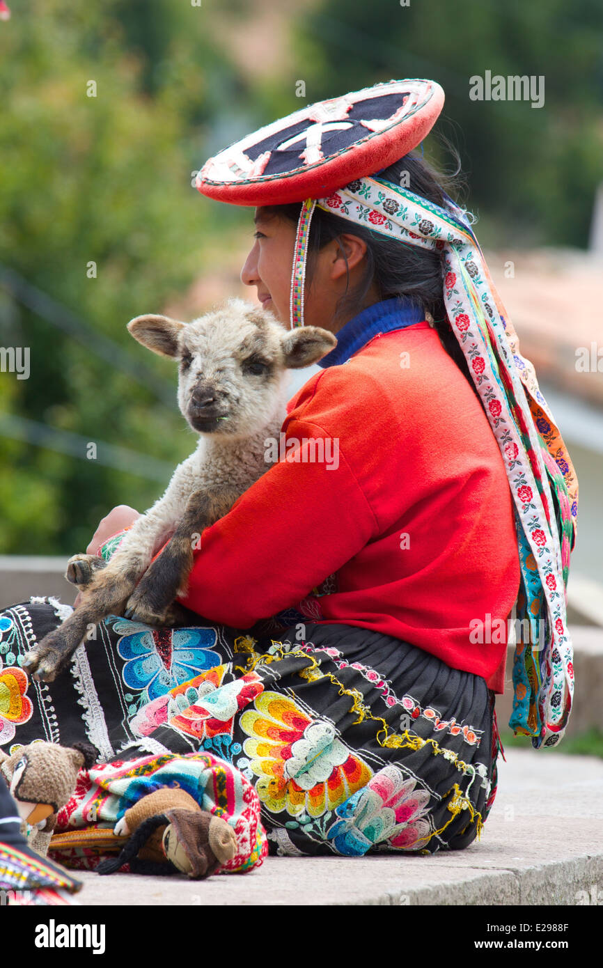 A portrait of a young Quechua woman in traditional native dress holding ...