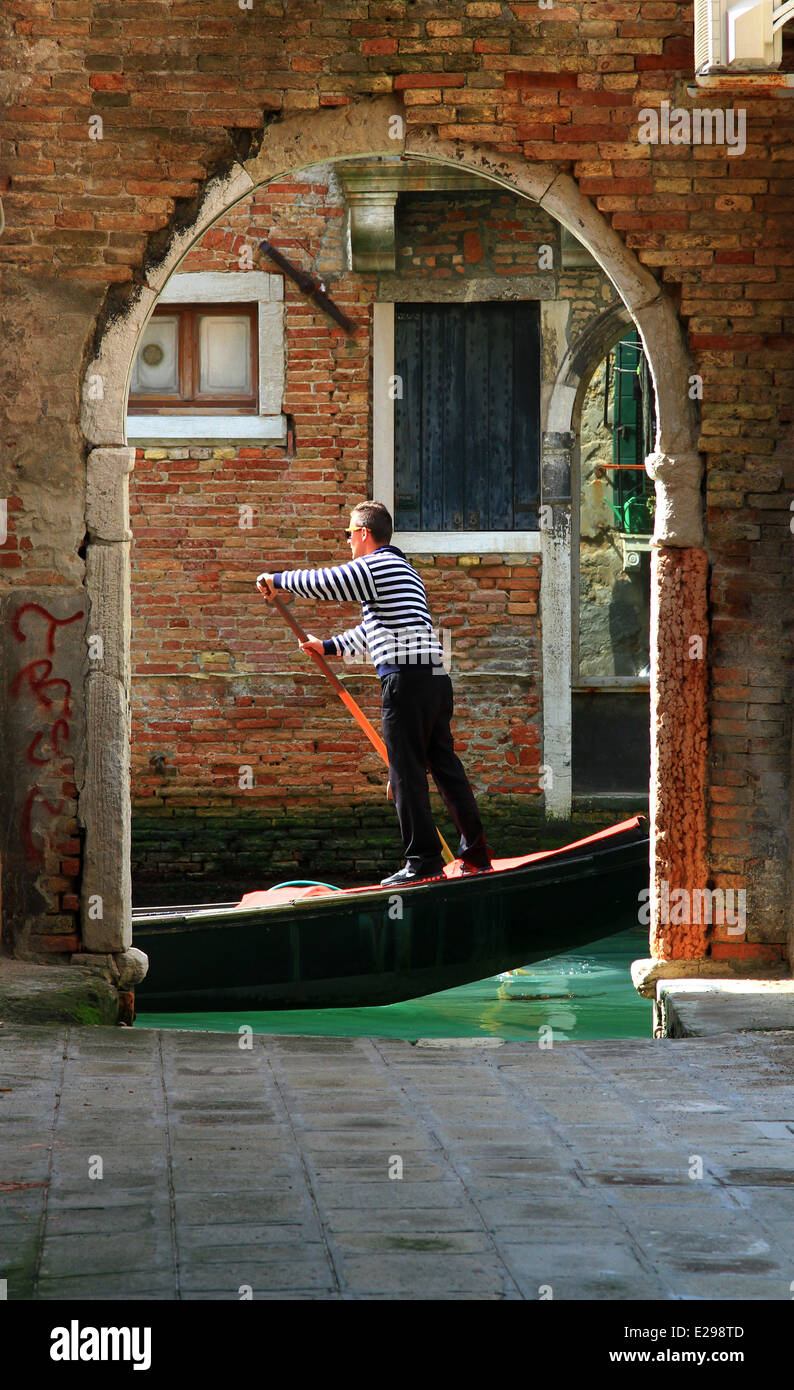 Venice gondola man, working the boat cornetto time, brick archway ...