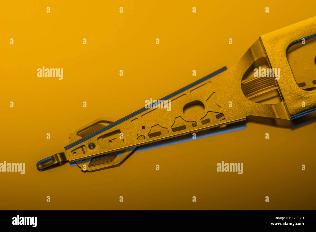 Macro photo of HDD read-write head and arm resting over disk platter ...