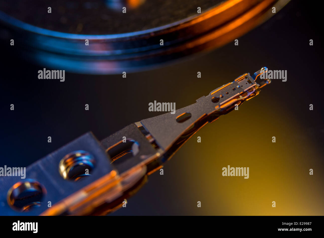 Macro photo of HDD read-write head and arm resting over disk platter ...