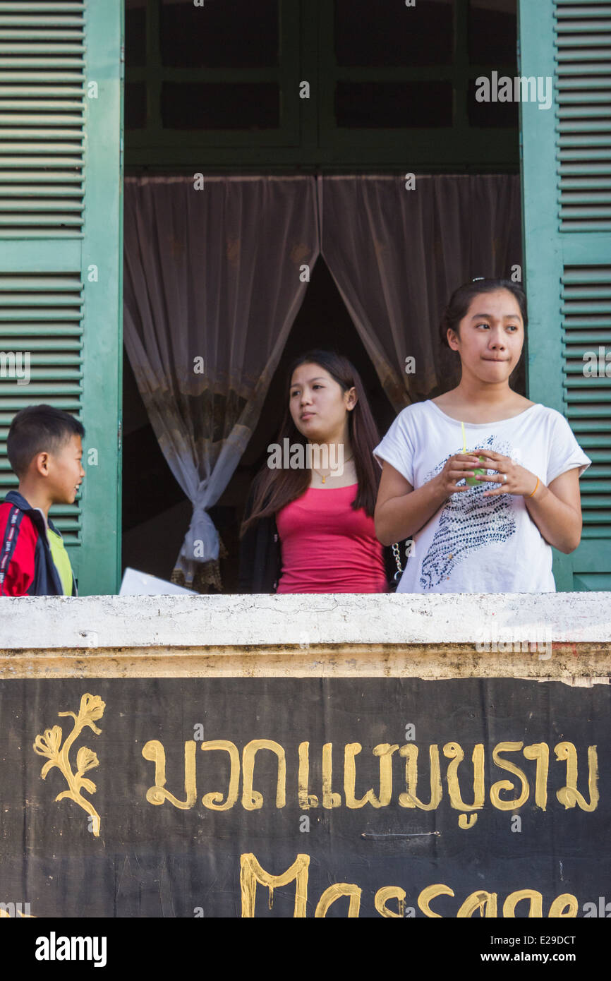 Lao locals on a balcony in the ancient town of Luang Prabang, situated ...