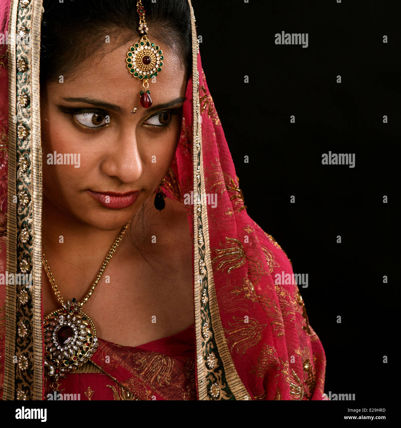 Portrait of beautiful young Indian girl looking to copy space at side ...