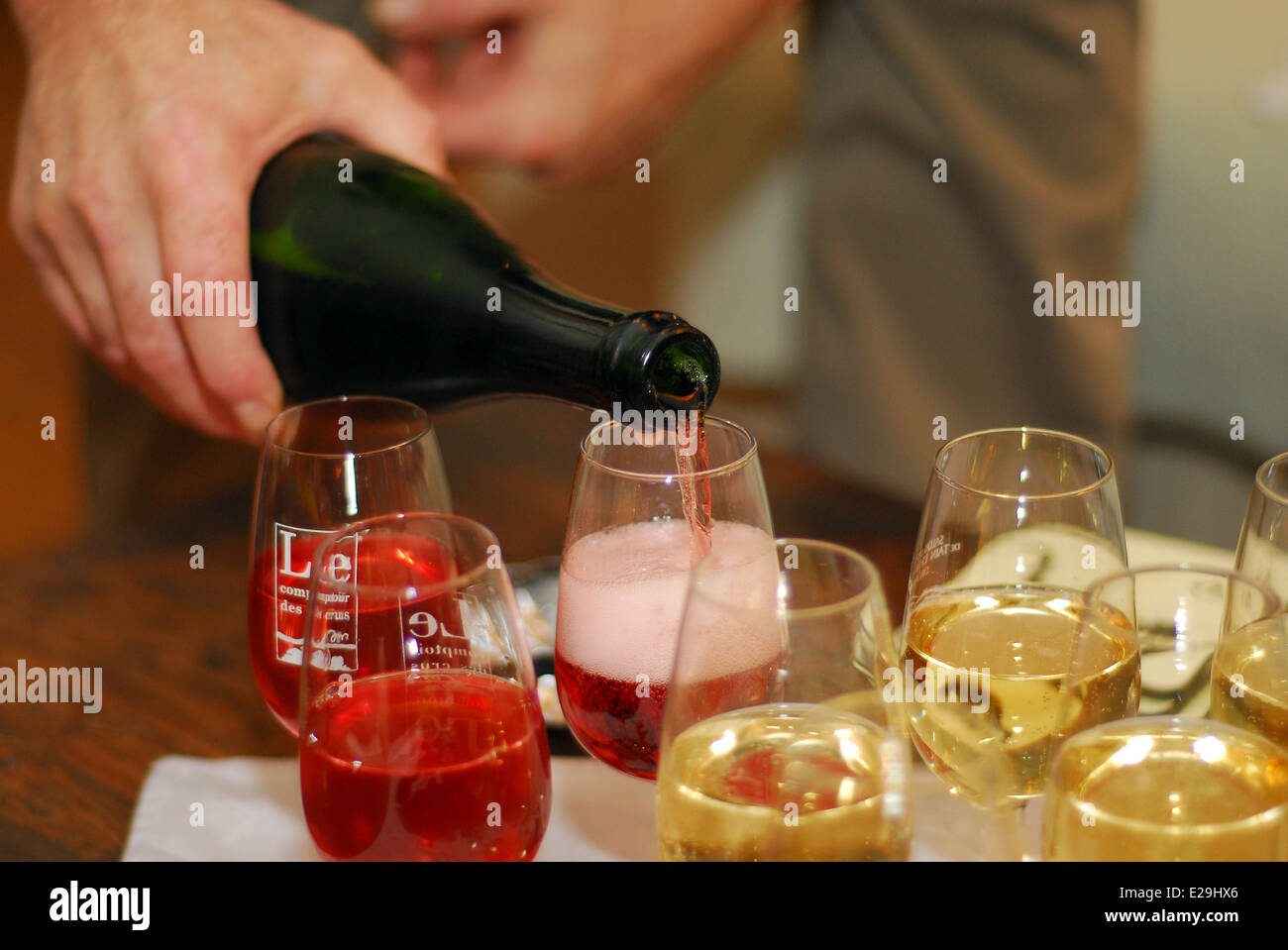 Man pouring sparkling wine into glasses Stock Photo - Alamy