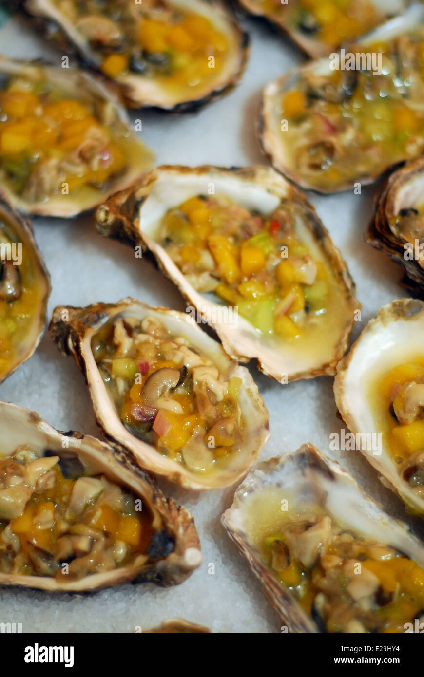 Presentation of an oyster recipe with the shells on a plate fill with ...