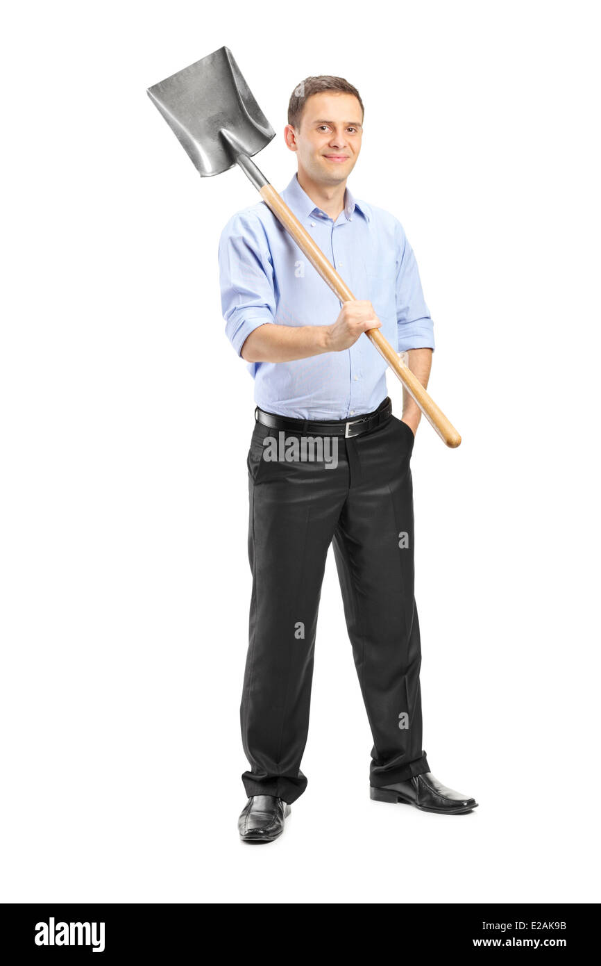 Full length portrait of a young man posing with a shovel over his ...