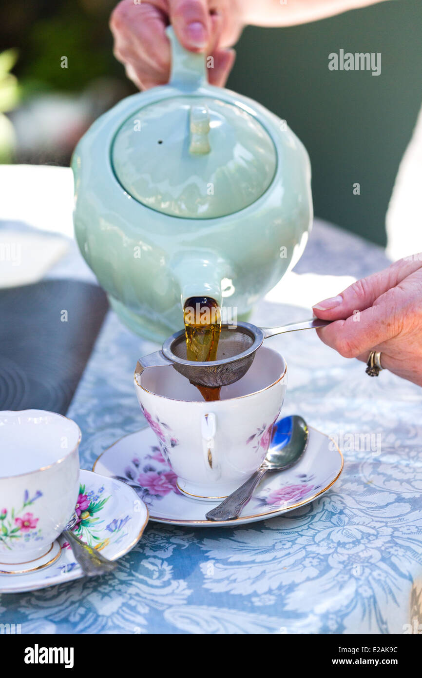 Enjoying afternoon tea. Woman pouring cup of tea at Ludham village ...