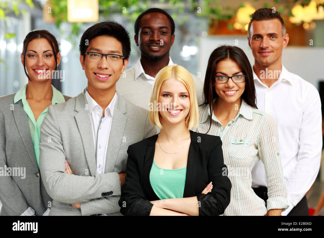 Happy group of co-workers standing in office Stock Photo - Alamy