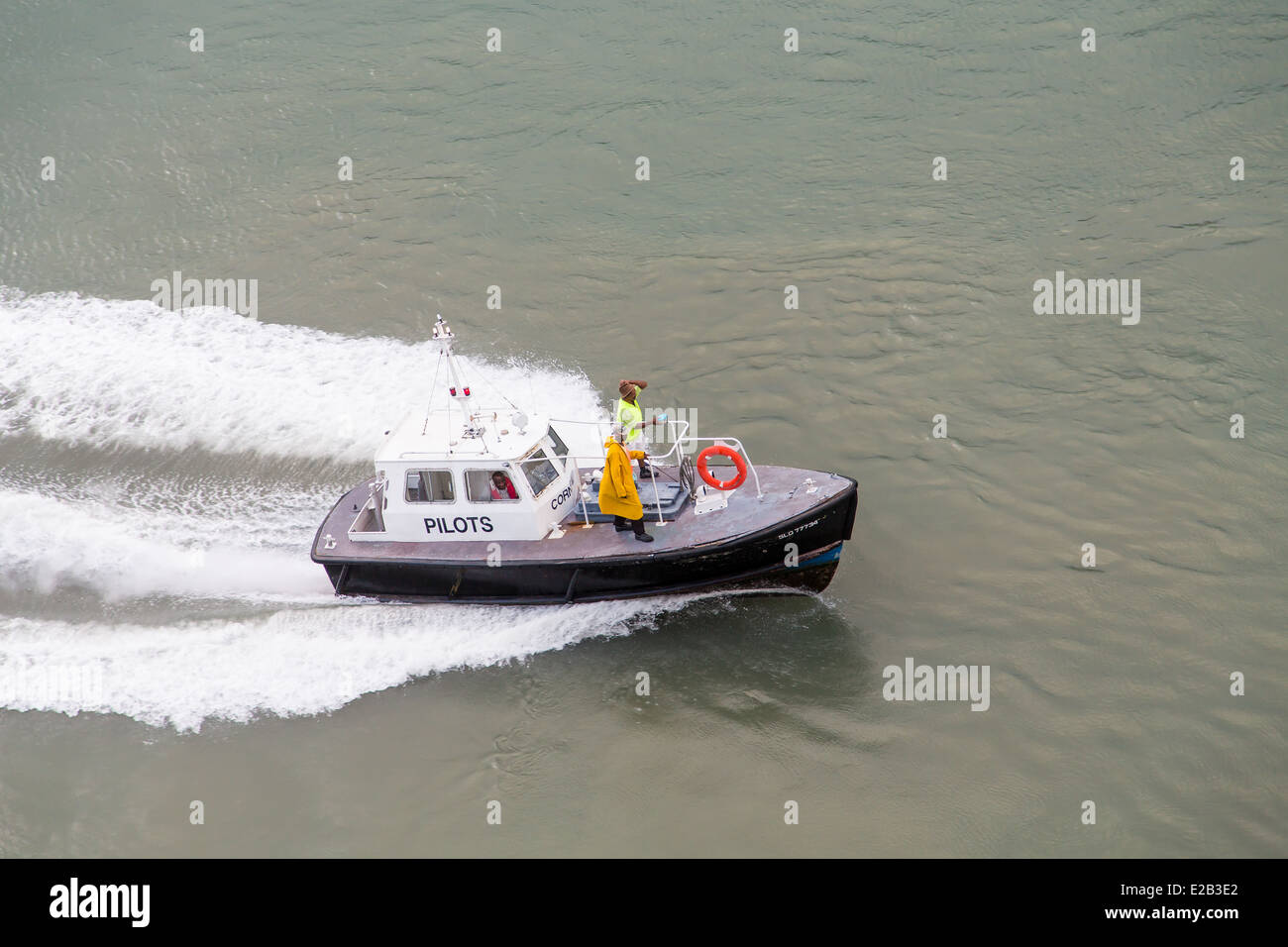 Three men on pilot boat speeding across a harbor Stock Photo - Alamy