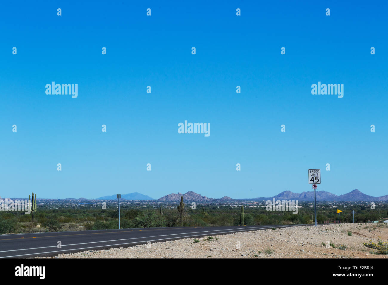 Desert road with speed limit and mountains Stock Photo - Alamy