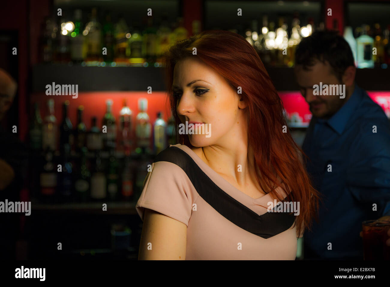 Girl in a bar having a drink while posing Stock Photo - Alamy