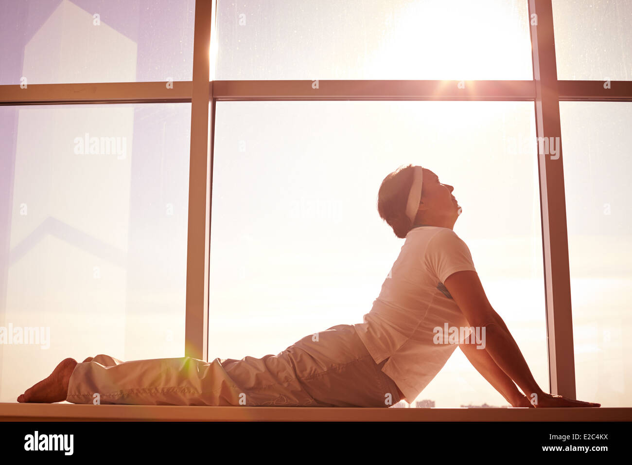 Silhouette of female doing physical exercise on background of window ...