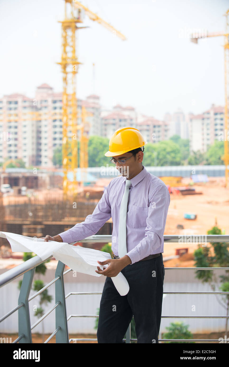 indian male engineer reading plans with construction background Stock ...