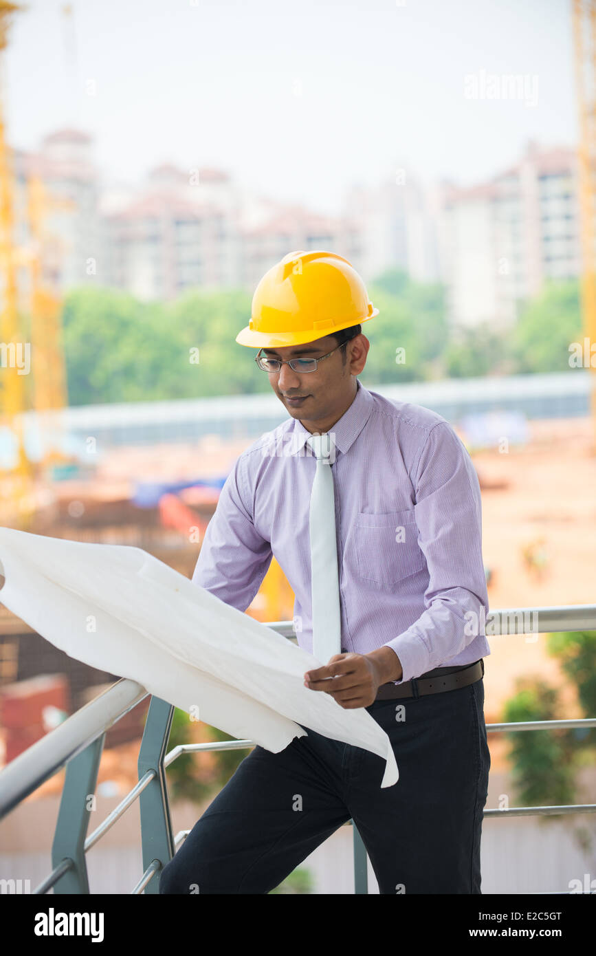 indian male engineer reading plans with construction background Stock ...