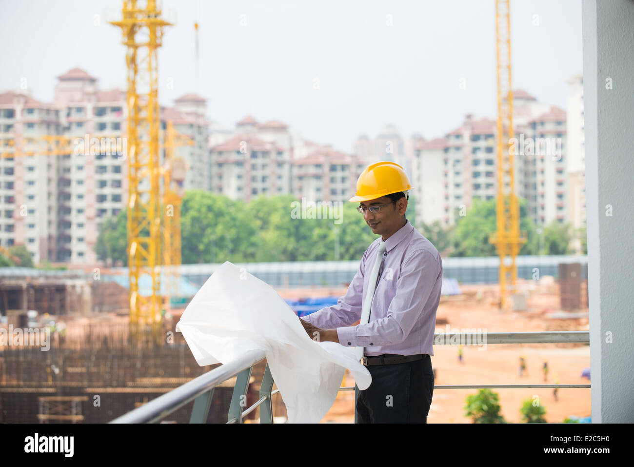 indian male engineer reading plans with construction background Stock ...