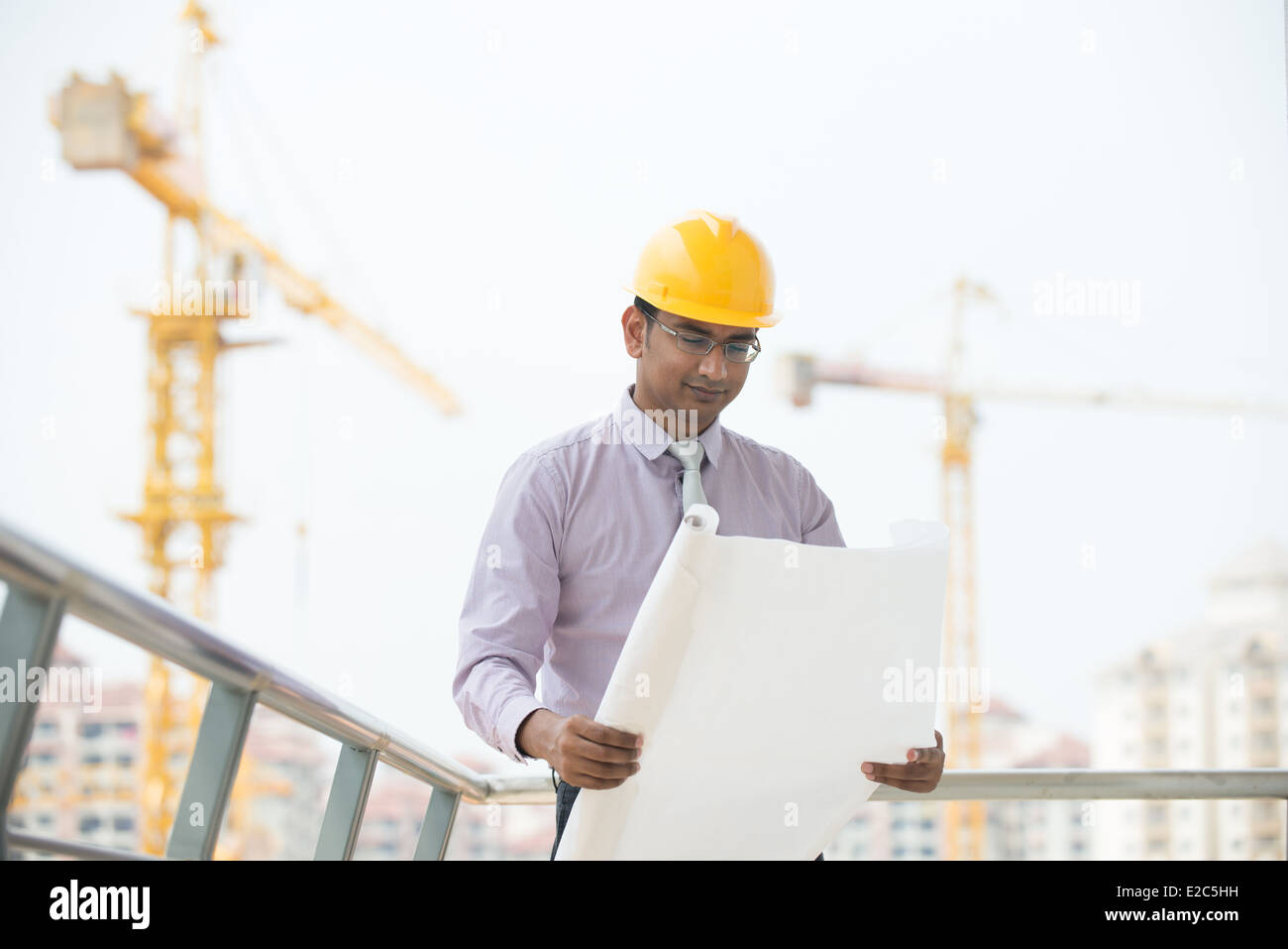 indian male engineer reading plans with construction background Stock ...
